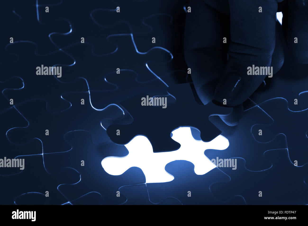 puzzle piece coming down into its place Stock Photo - Alamy
