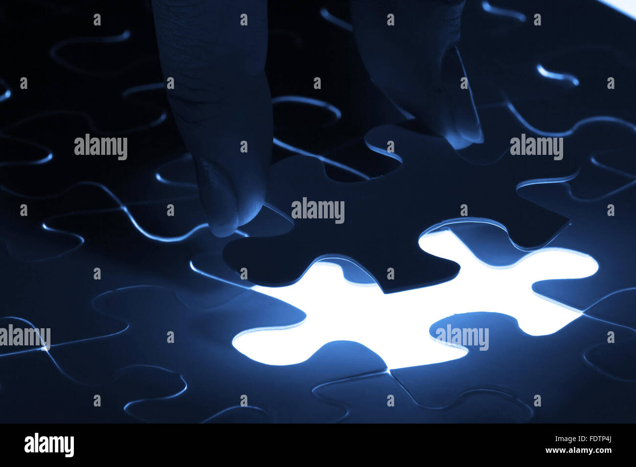 puzzle piece coming down into its place Stock Photo - Alamy