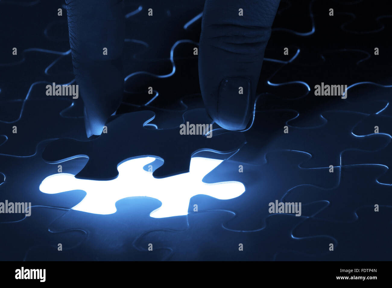puzzle piece coming down into its place Stock Photo - Alamy