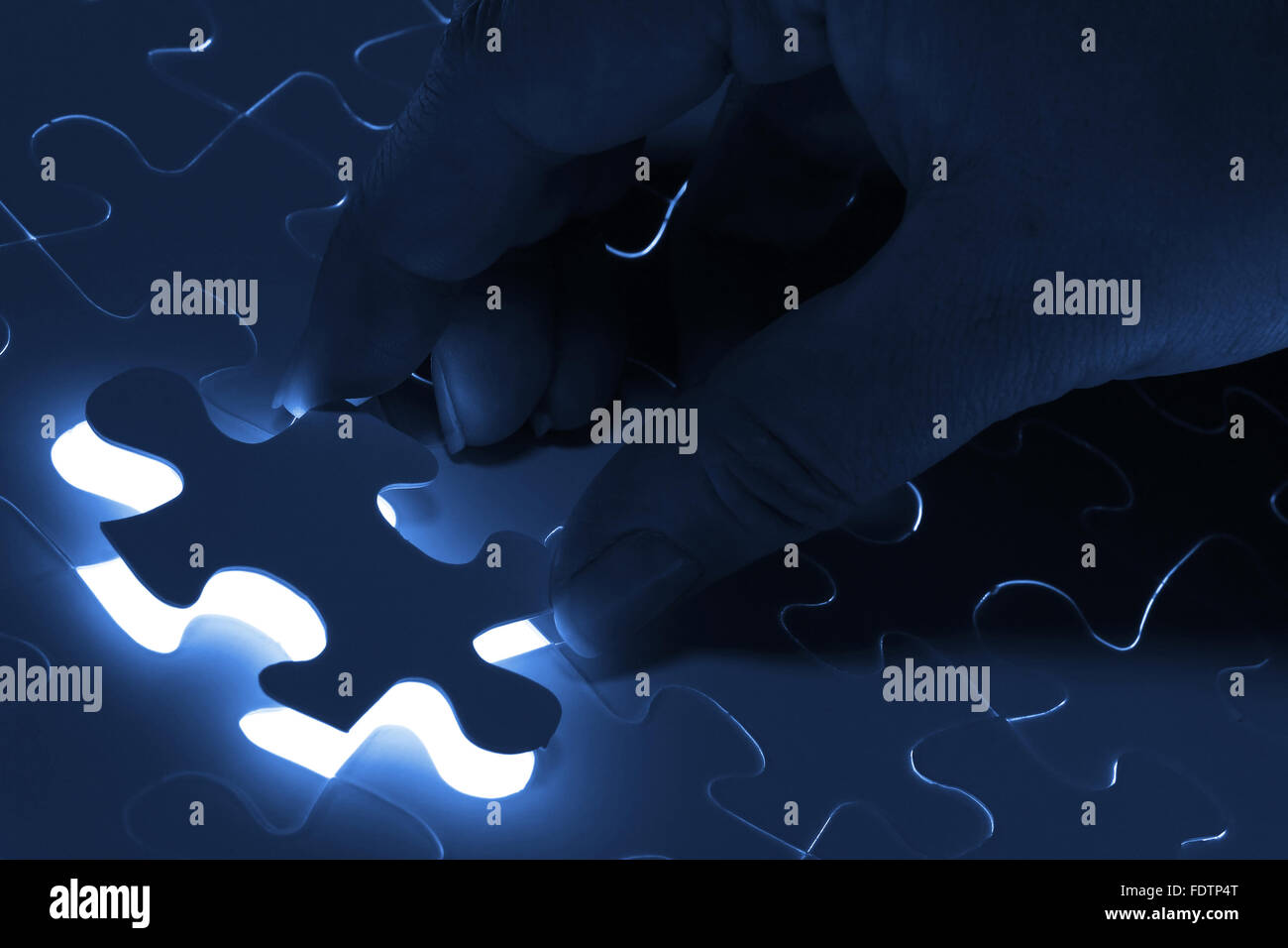 puzzle piece coming down into its place Stock Photo - Alamy