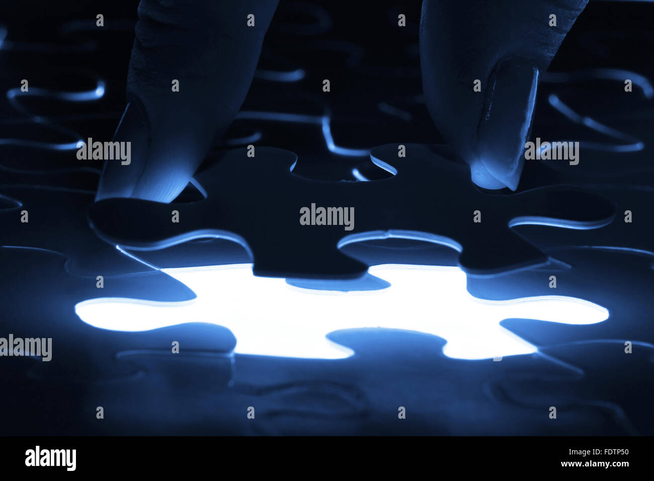 puzzle piece coming down into its place Stock Photo - Alamy