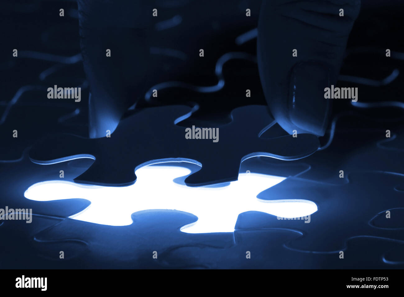 puzzle piece coming down into its place Stock Photo - Alamy