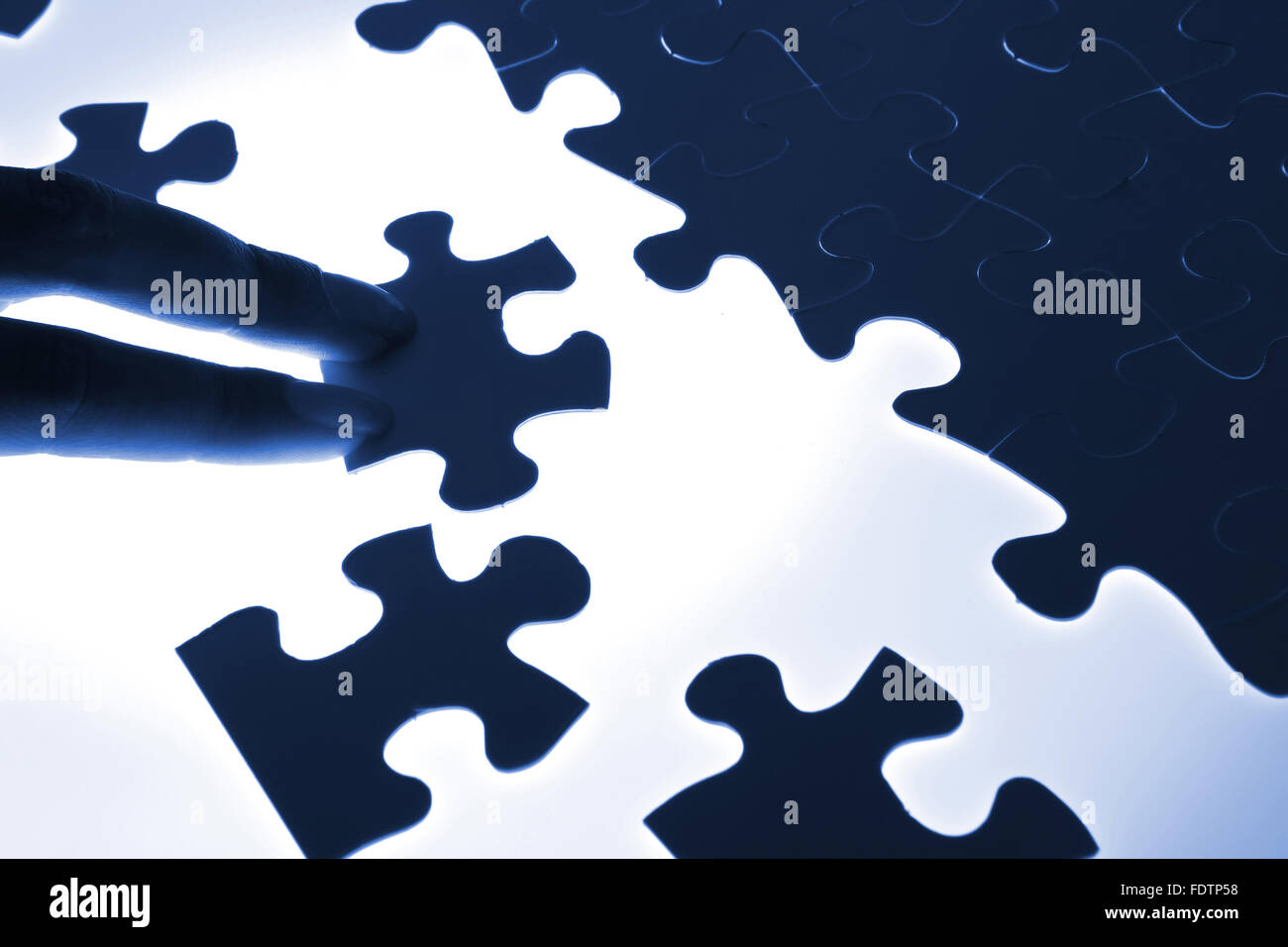puzzle piece coming down into its place Stock Photo - Alamy