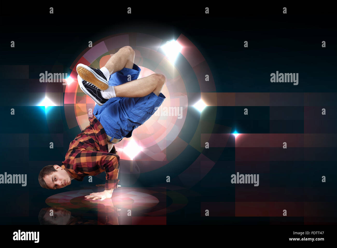 Modern style dancer posing against dark background with light effects ...