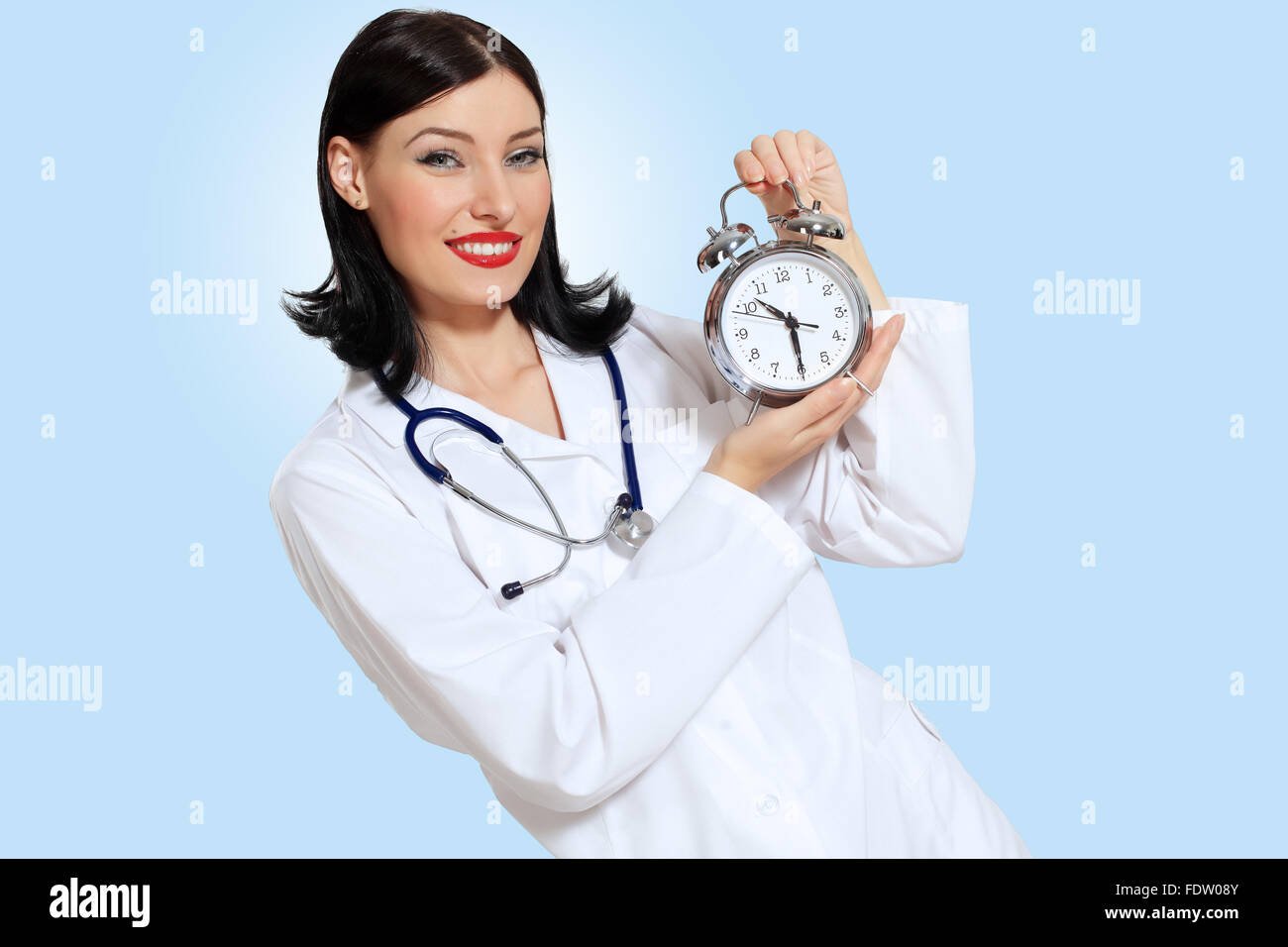 Portrait of happy successful young female doctor holding clocks Stock ...