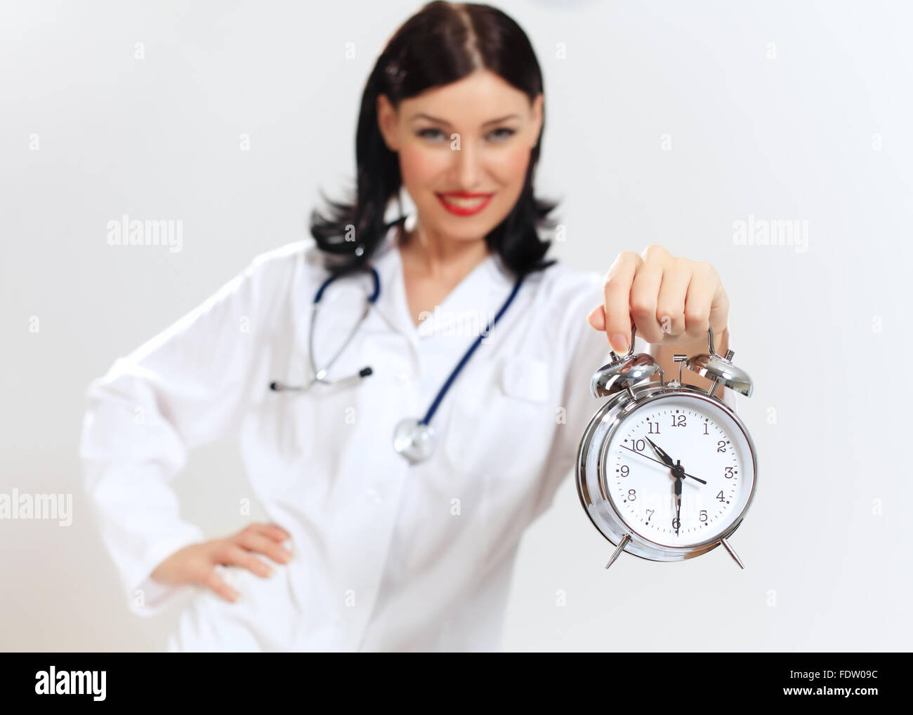 Portrait of happy successful young female doctor holding clocks Stock ...