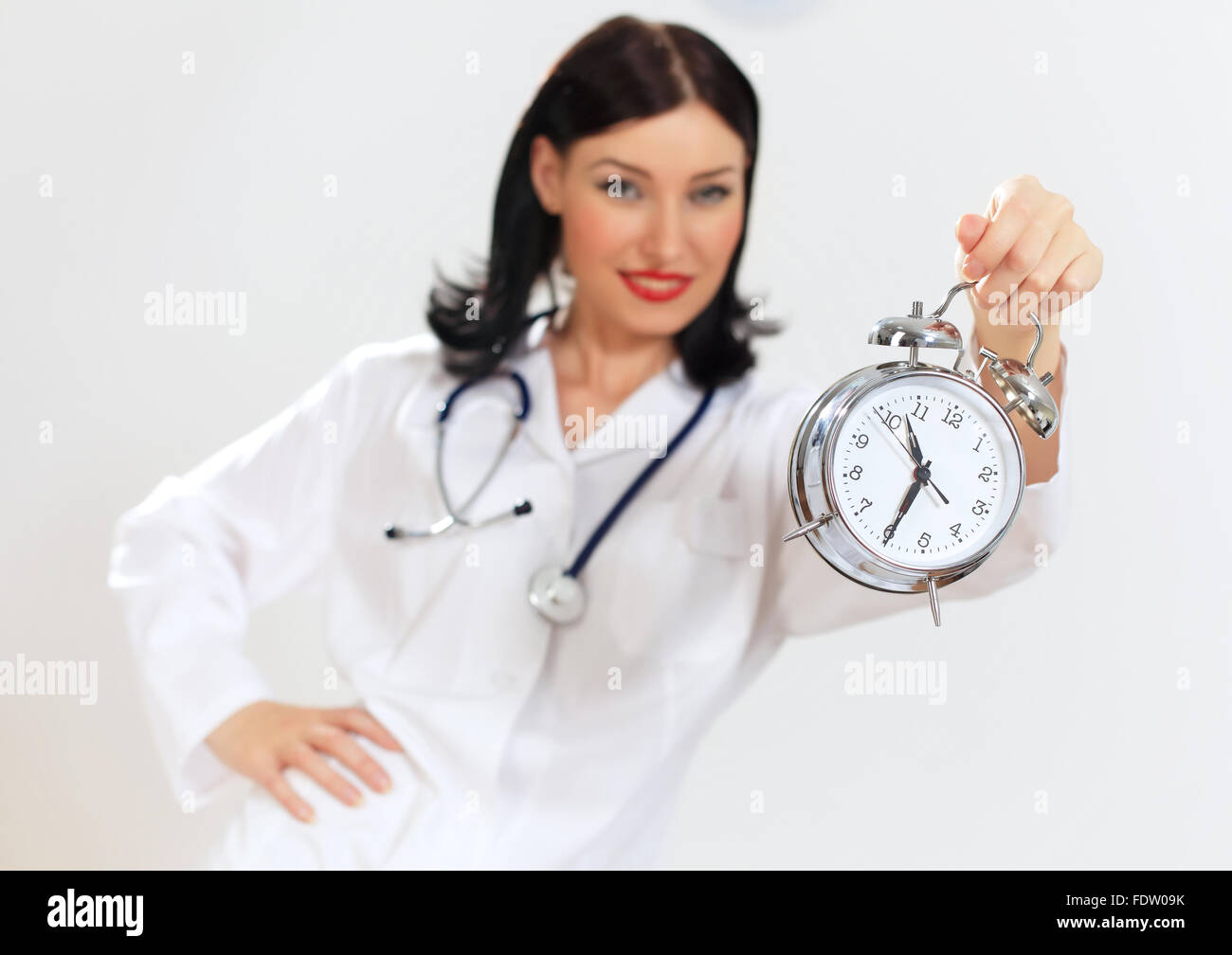 Portrait of happy successful young female doctor holding clocks Stock ...