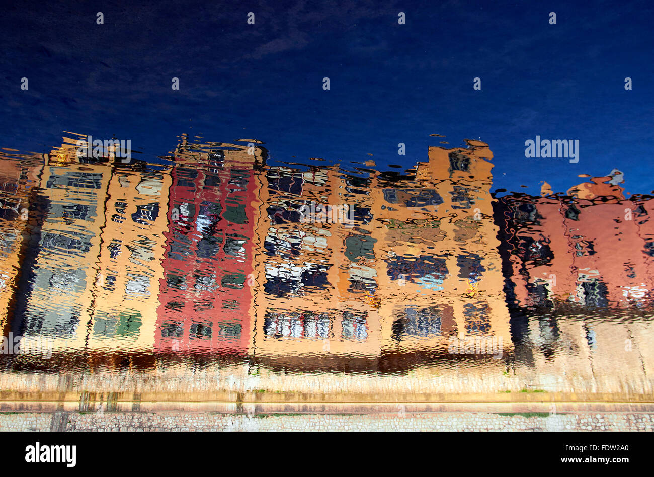 Old city buildings facade reflection in a river in Girona , Spain ...