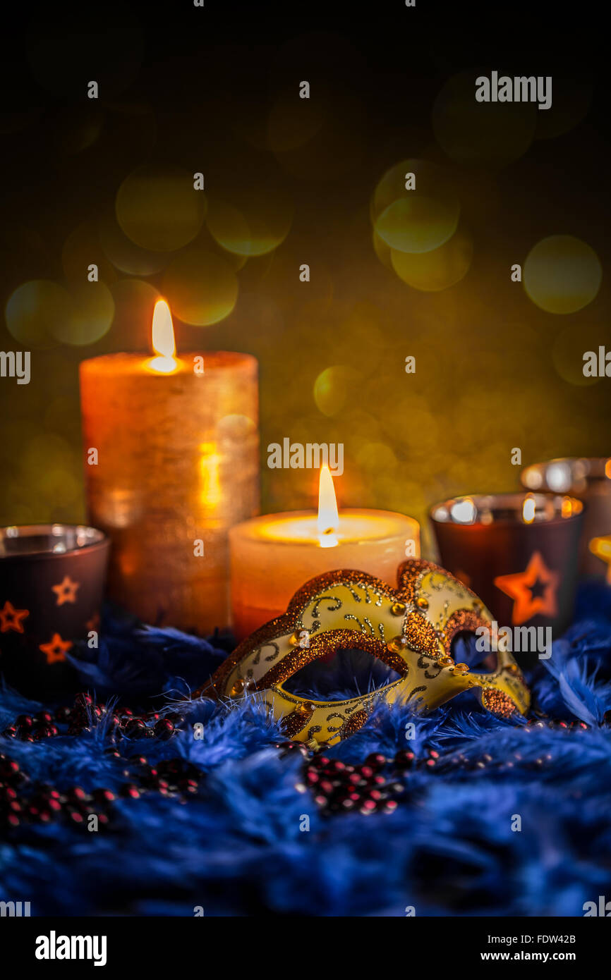 Classical venetian mask lying near lighting candle Stock Photo - Alamy
