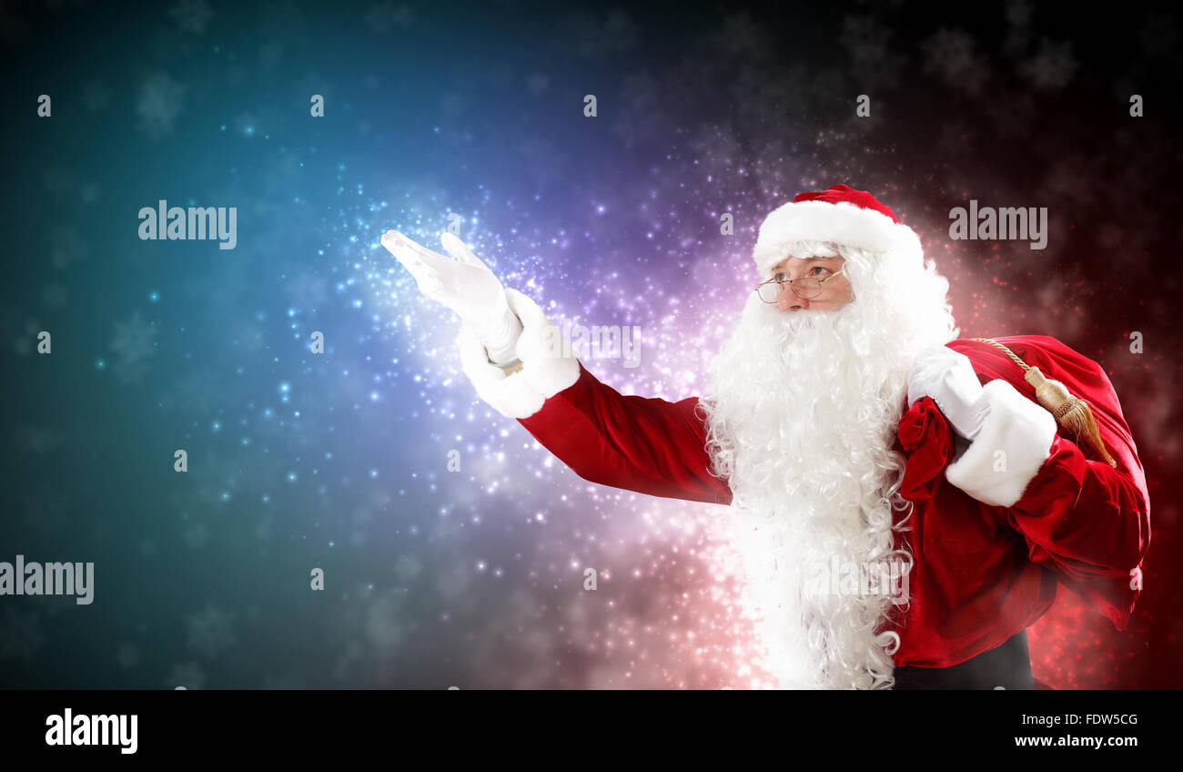 Christmas theme with Santa holding magical lights in hands Stock Photo ...