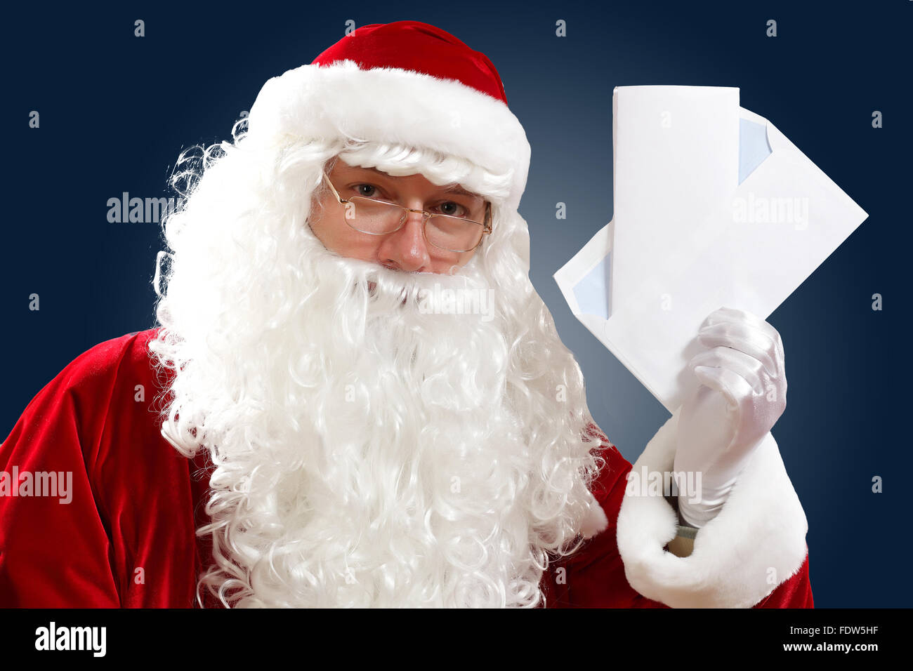Santa Claus holding and reading a letter to him Stock Photo - Alamy