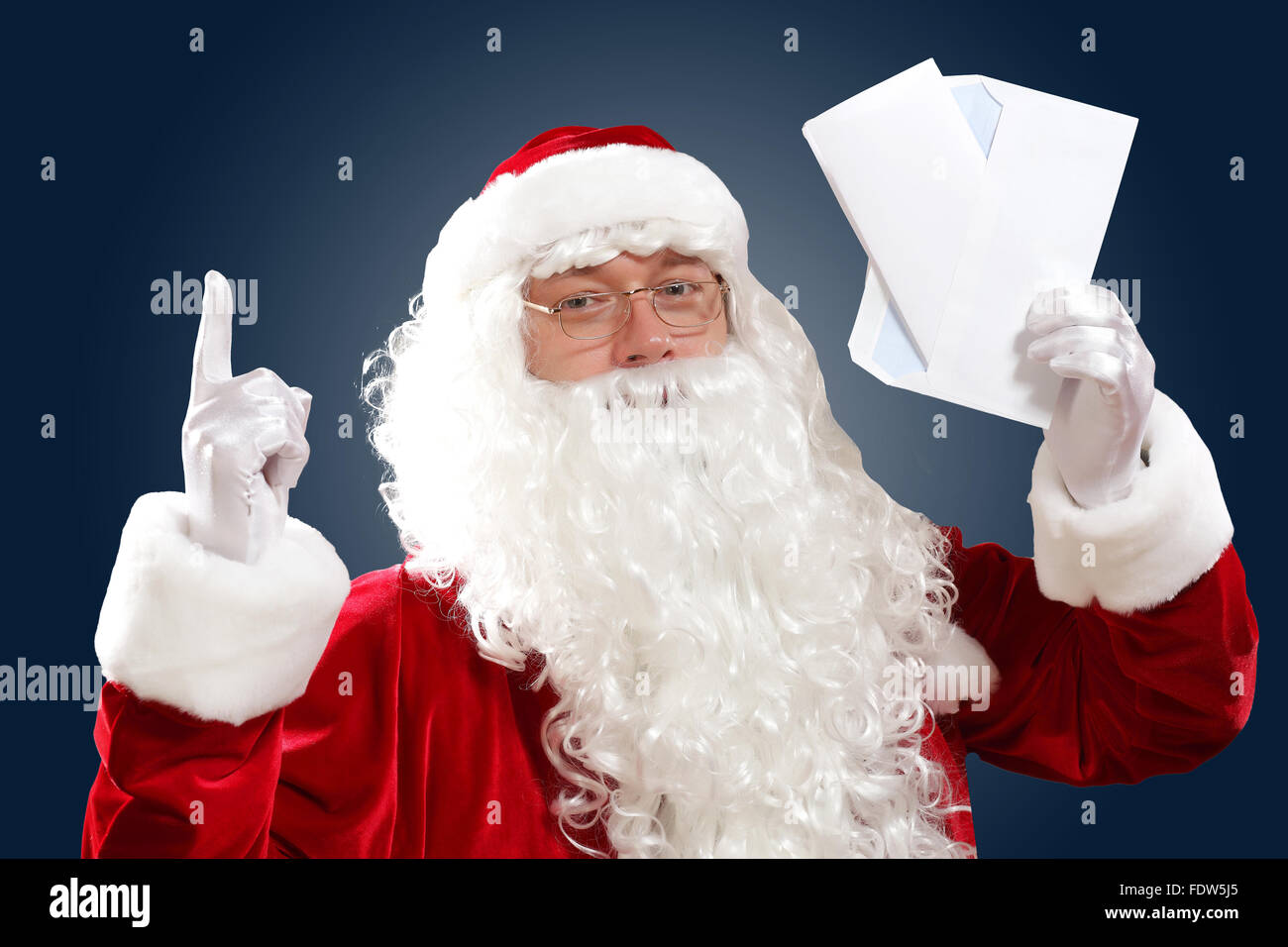 Santa Claus holding and reading a letter to him Stock Photo - Alamy