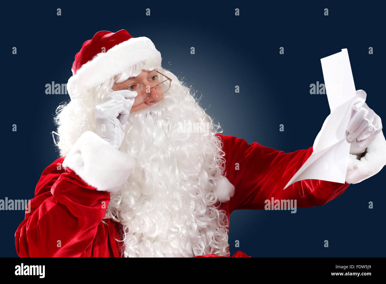 Santa Claus holding and reading a letter to him Stock Photo - Alamy
