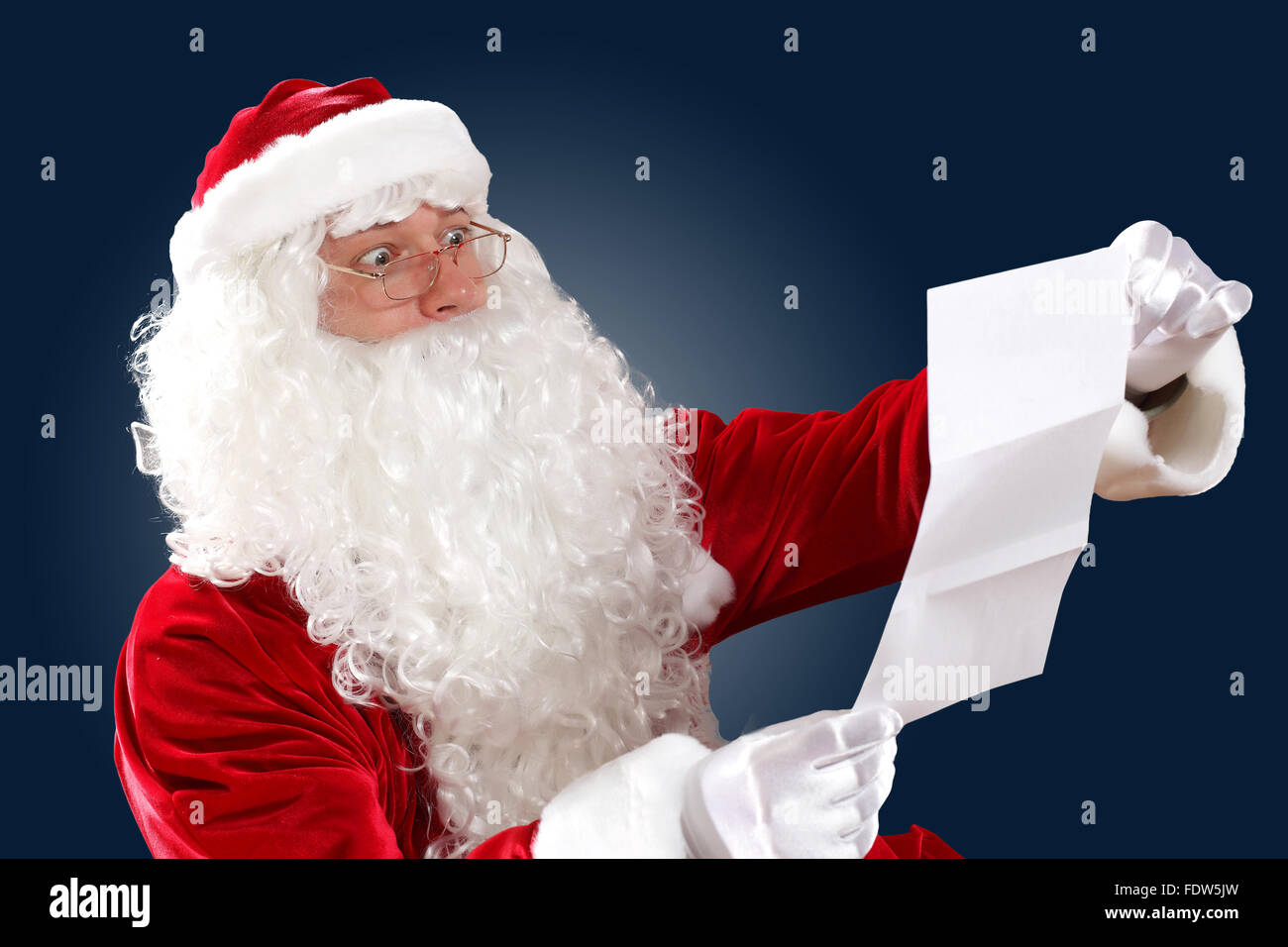 Santa Claus holding and reading a letter to him Stock Photo - Alamy