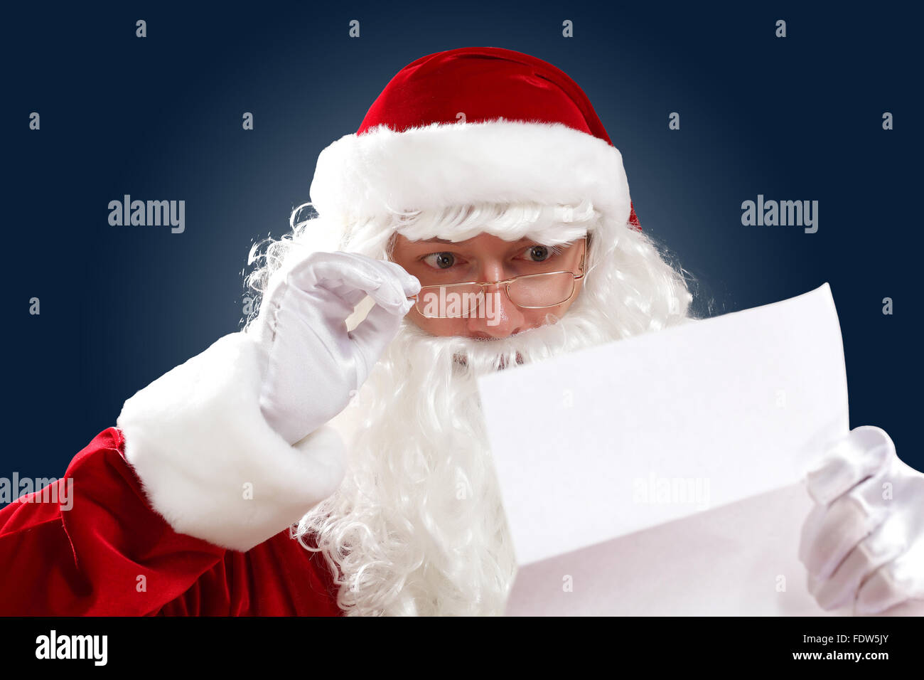 Santa Claus holding and reading a letter to him Stock Photo - Alamy