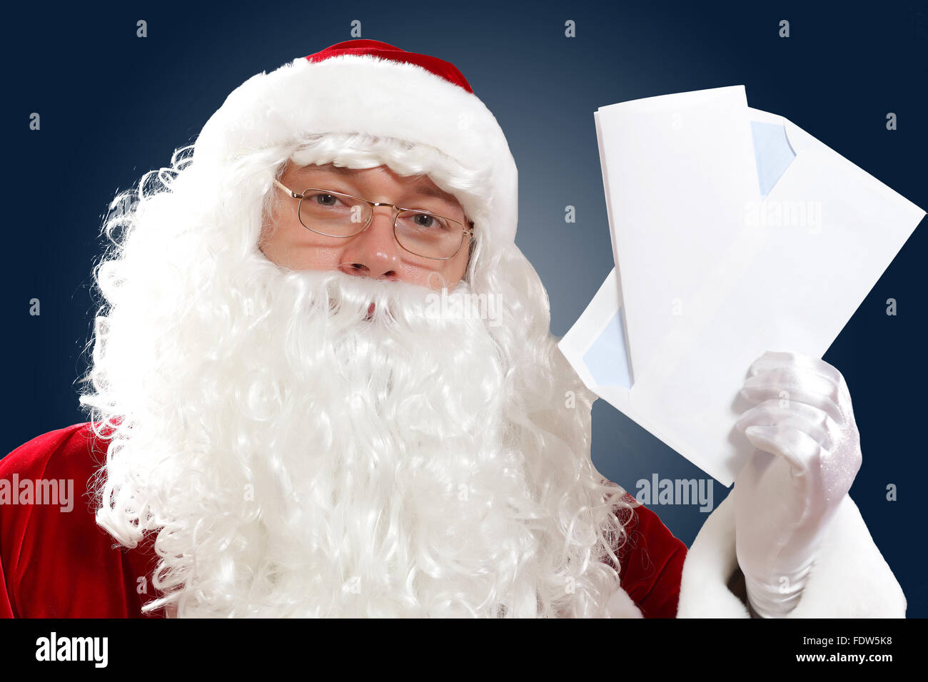Santa Claus holding and reading a letter to him Stock Photo - Alamy