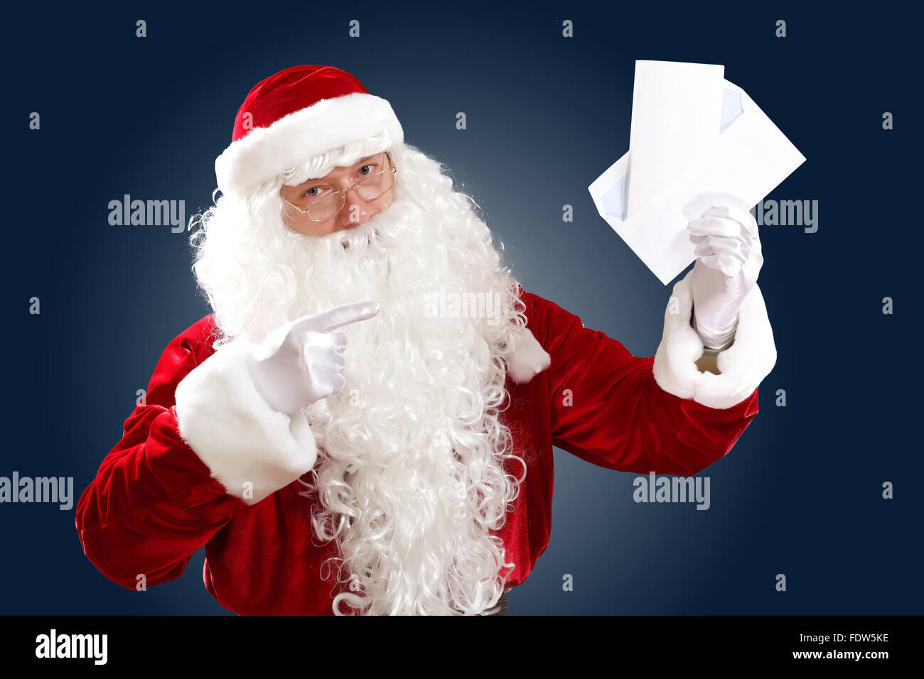 Santa Claus holding and reading a letter to him Stock Photo - Alamy