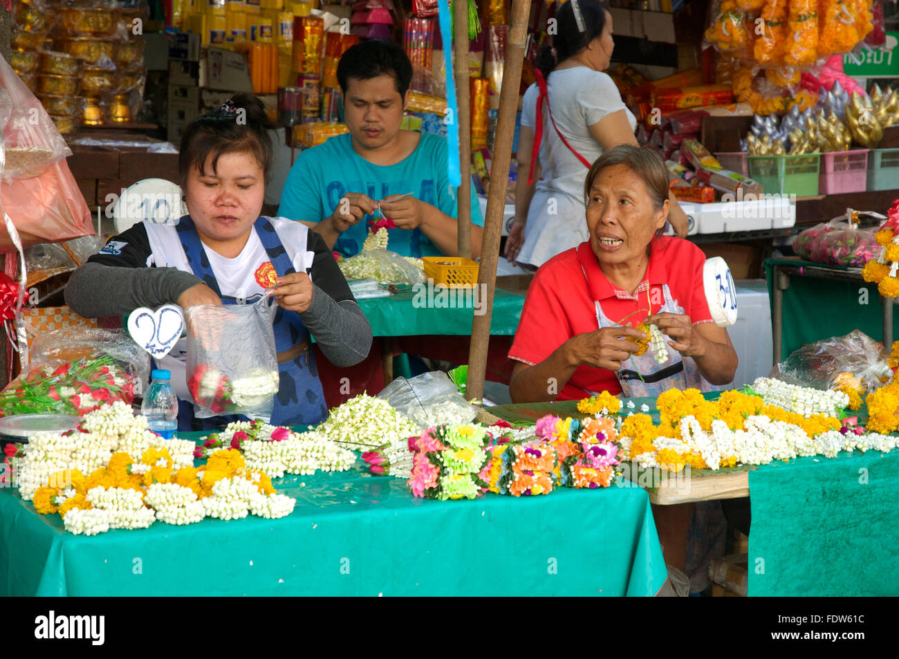 three members of family constructing flower chains for sale Stock Photo ...