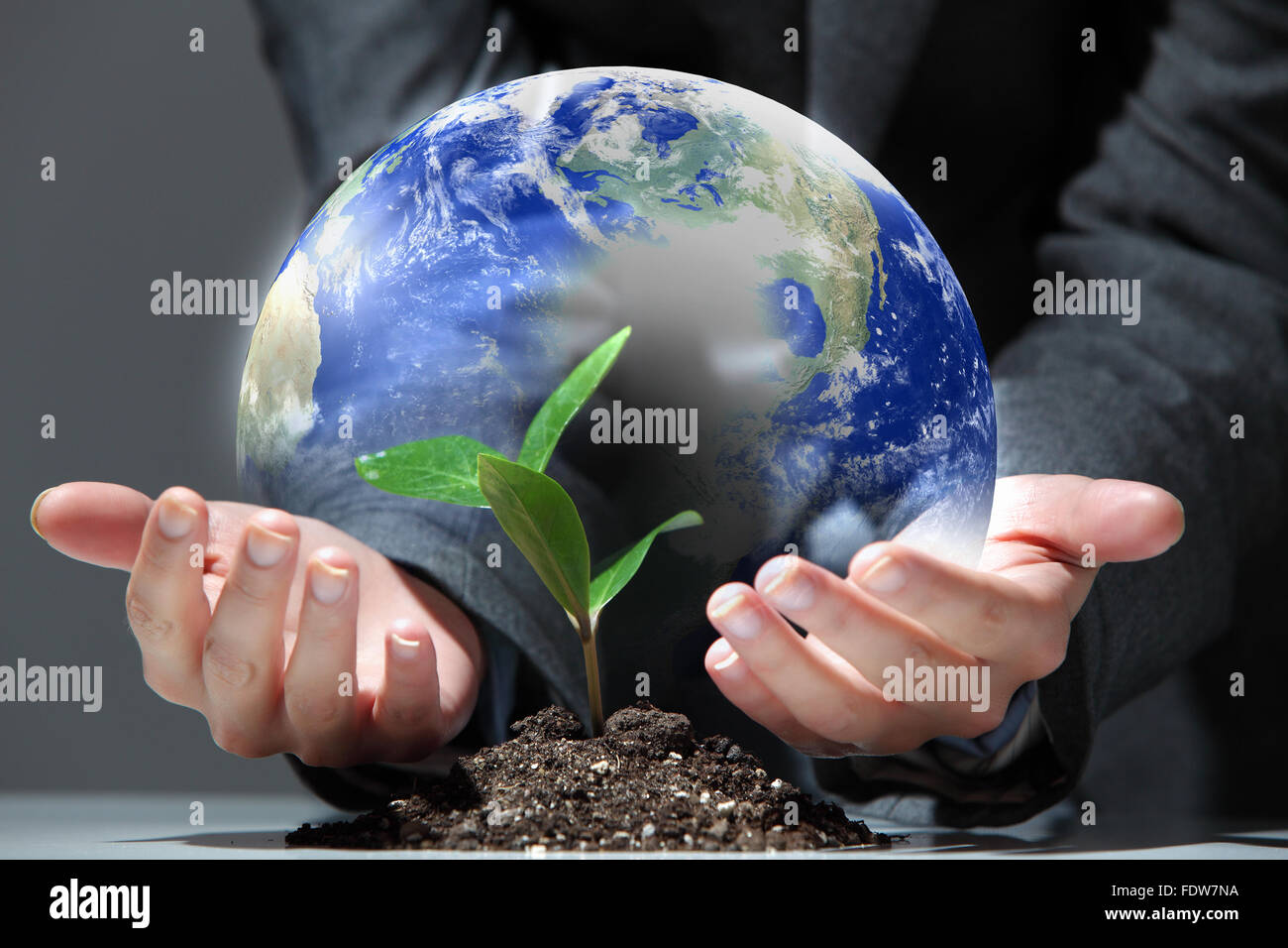 hands, the young sprout and our planet Earth Stock Photo - Alamy
