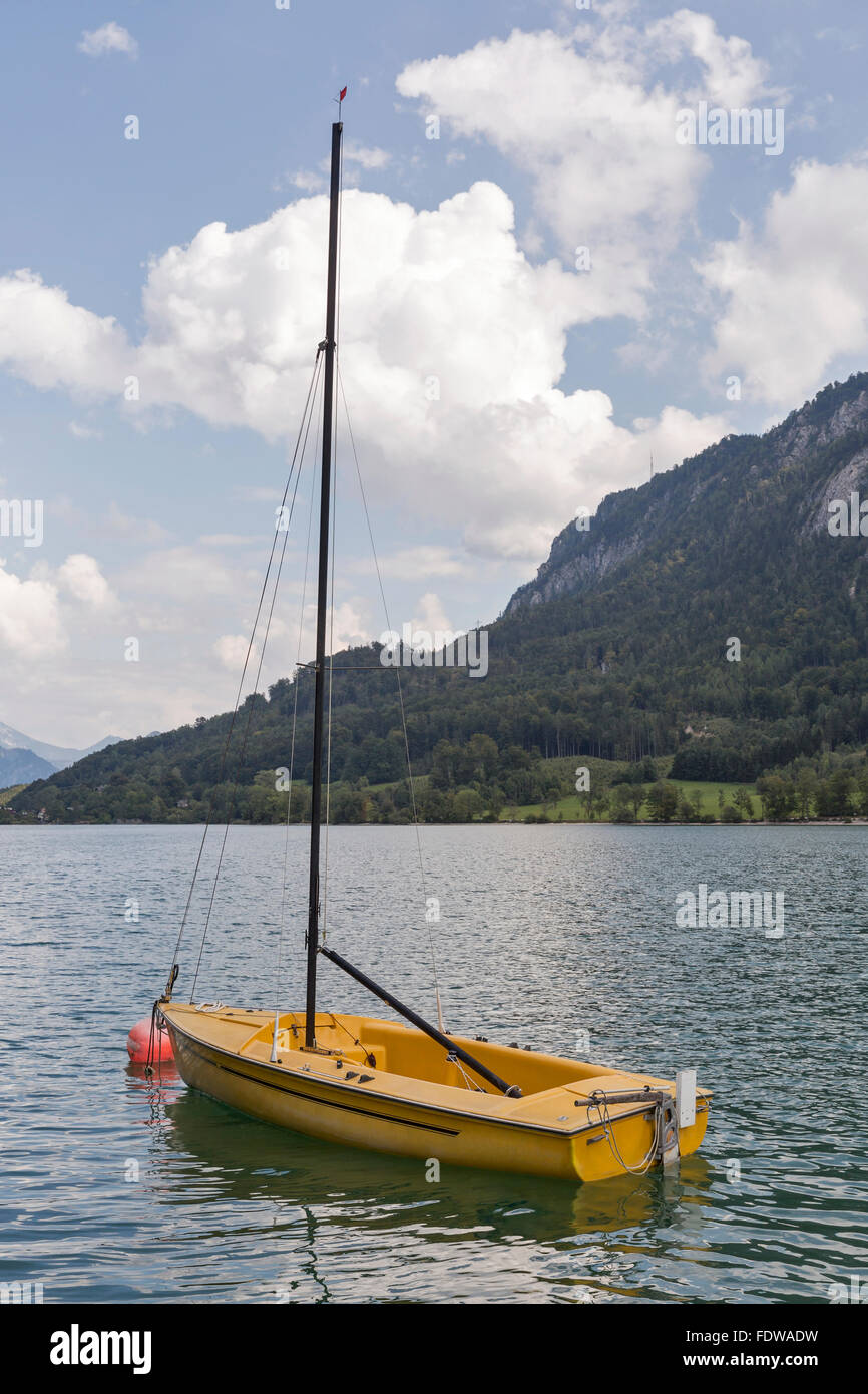 small yellow sailing yacht without sails on Alpine lake Mondsee in ...