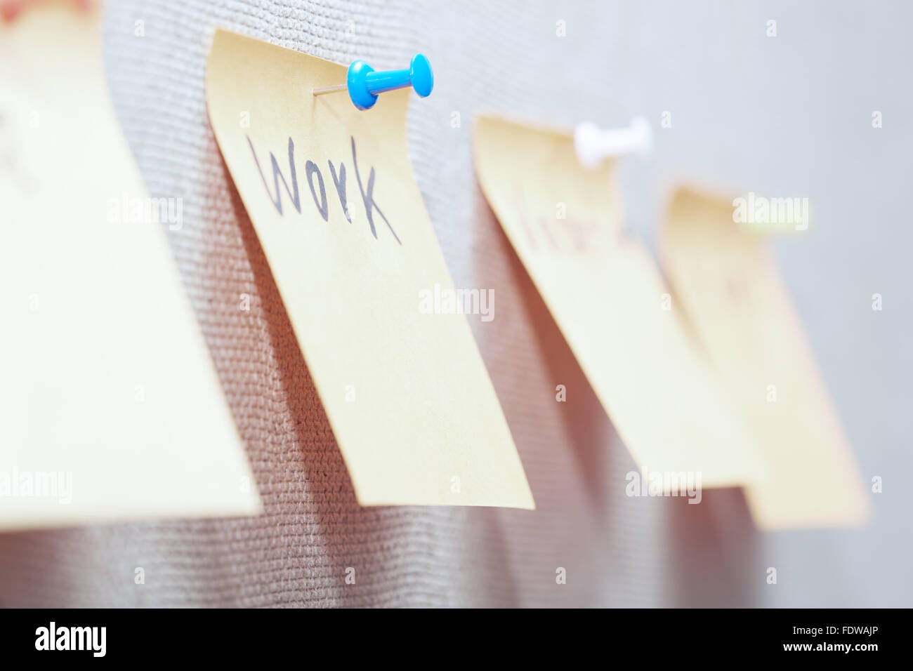 Adhesive note with Work text on a bulletin board Stock Photo - Alamy