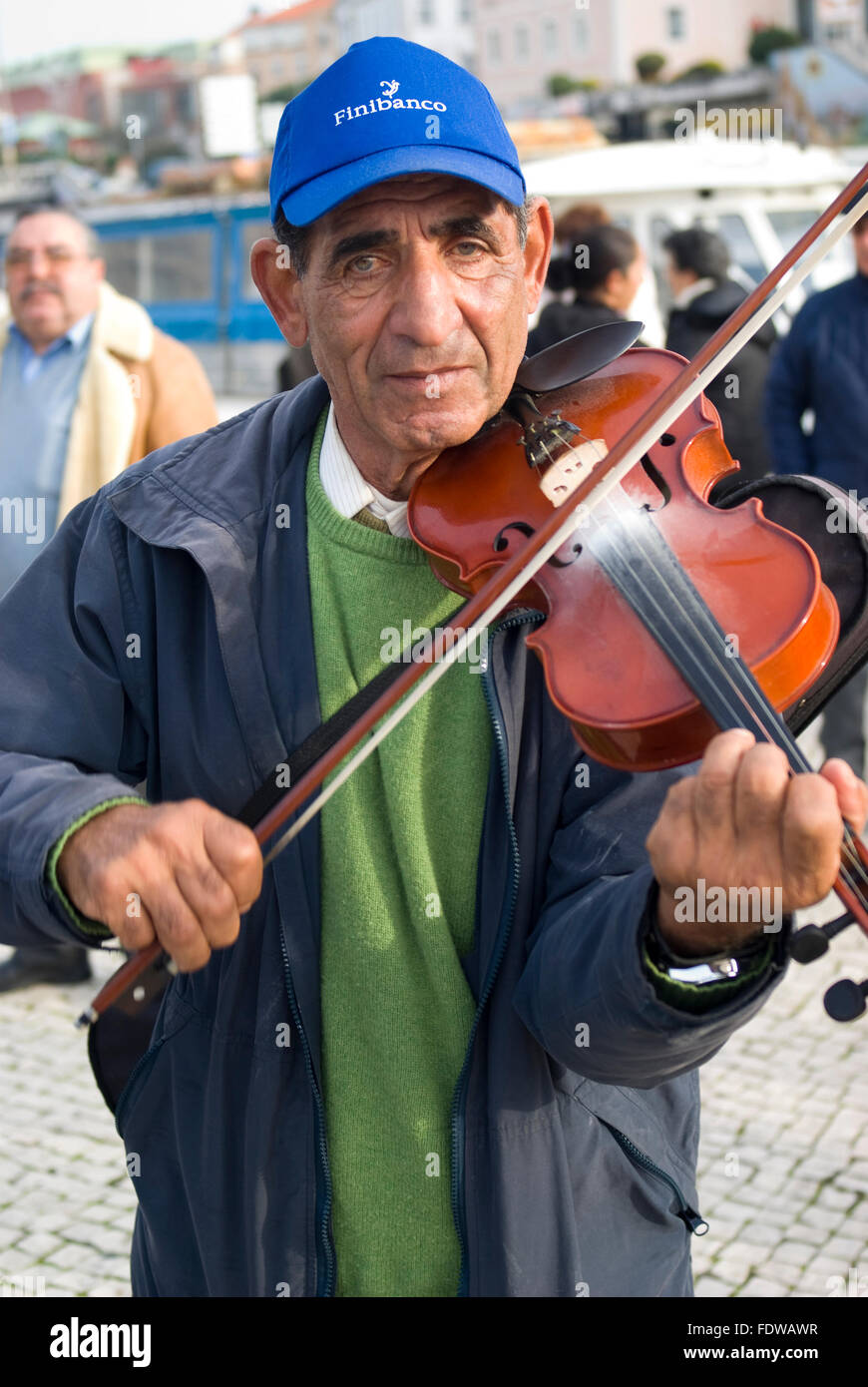 Elderly man busker playing violin on the street of Coimbra, Portugal ...