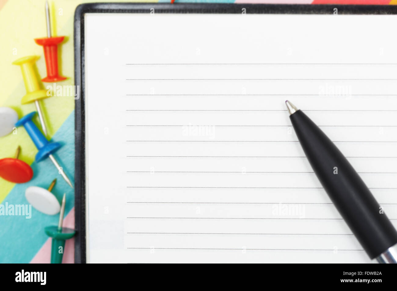 Notepad with pen and pushpins. Close-up photo Stock Photo - Alamy