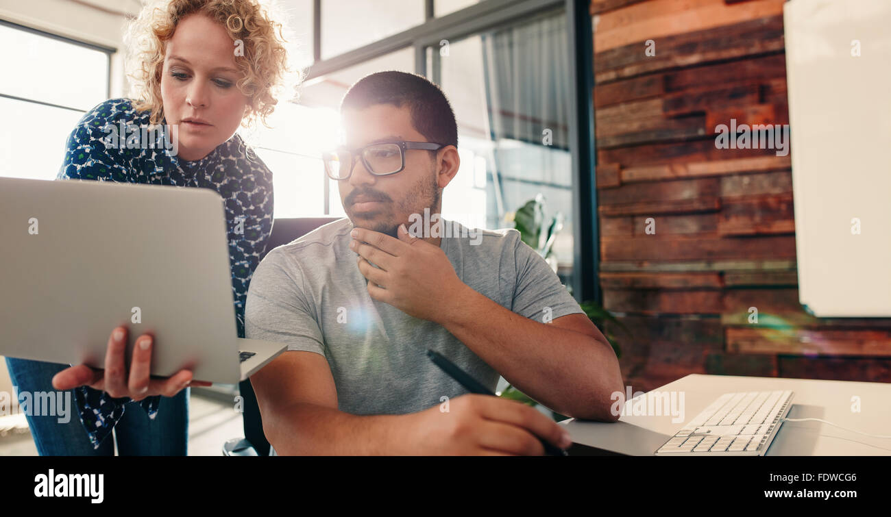 Portrait of young team of graphic designers working together in a new ...