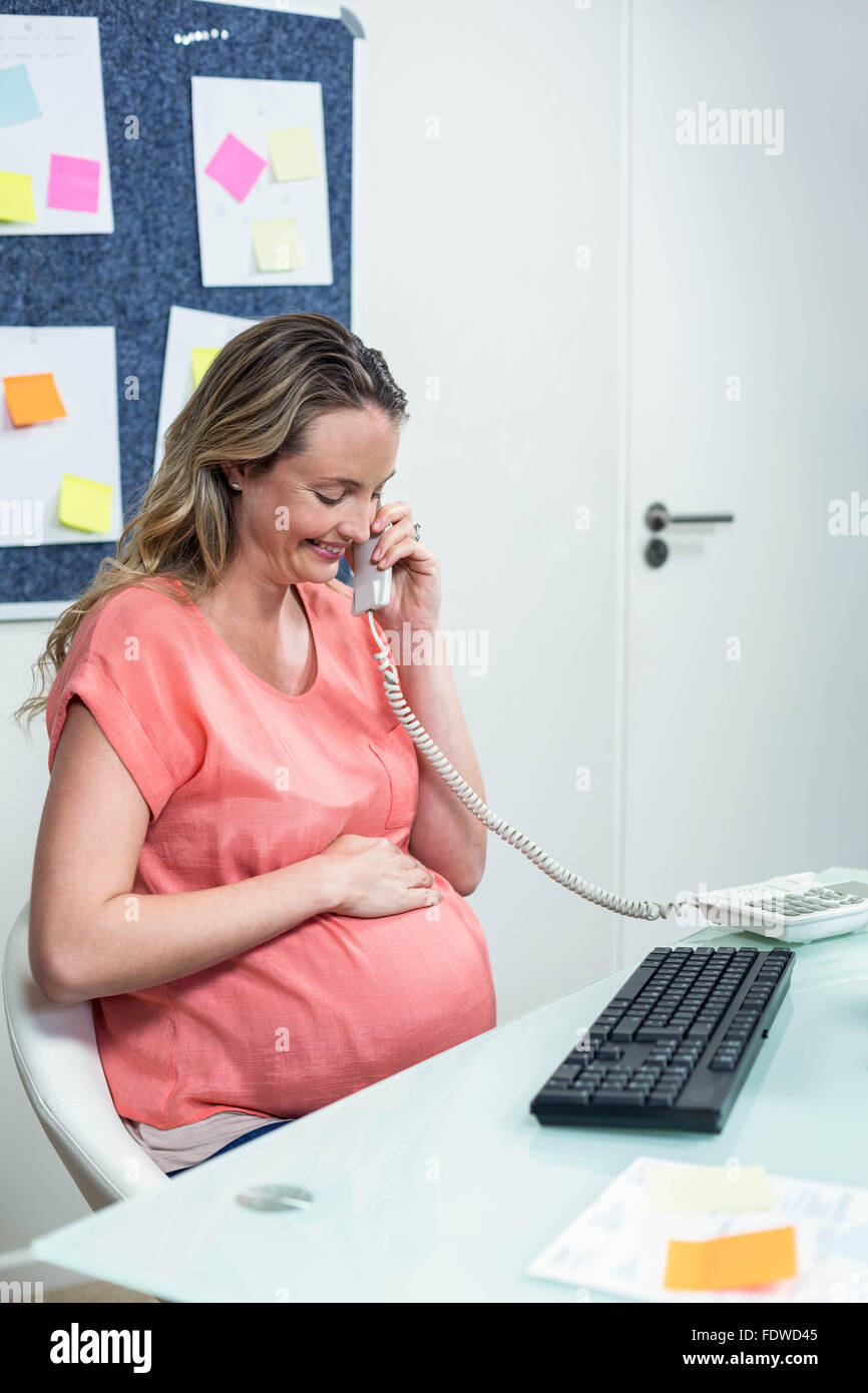 Pregnant woman using computer and phone Stock Photo - Alamy