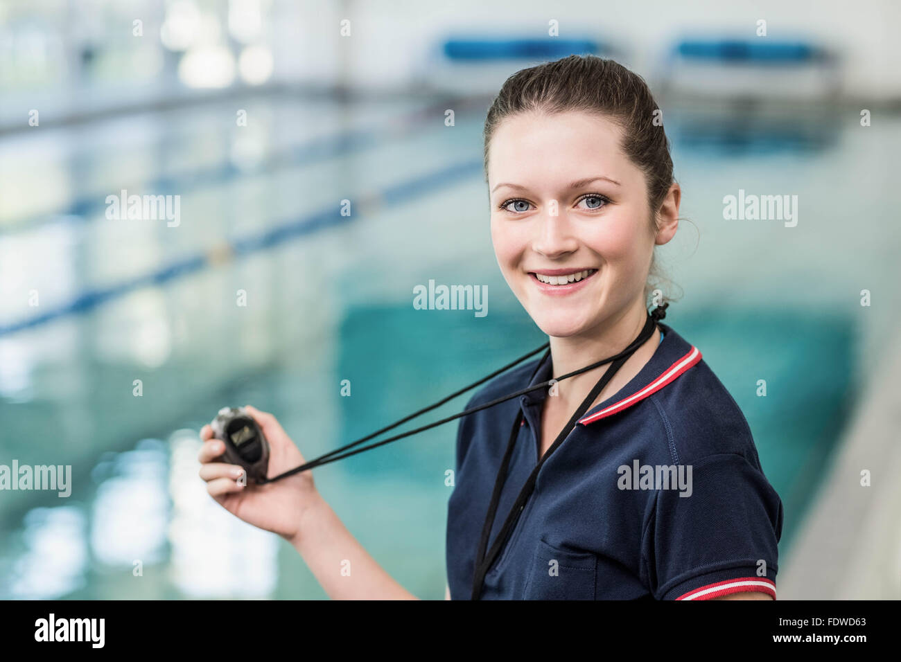 Pretty trainer holding stopwatch Stock Photo - Alamy
