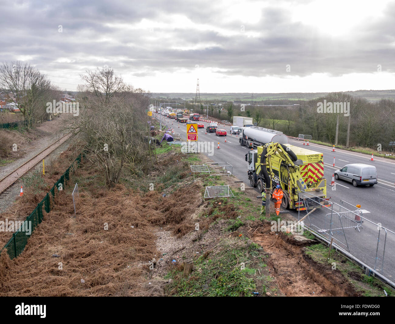 Workers on side of a coned off dual carriageway doing maintenance work ...