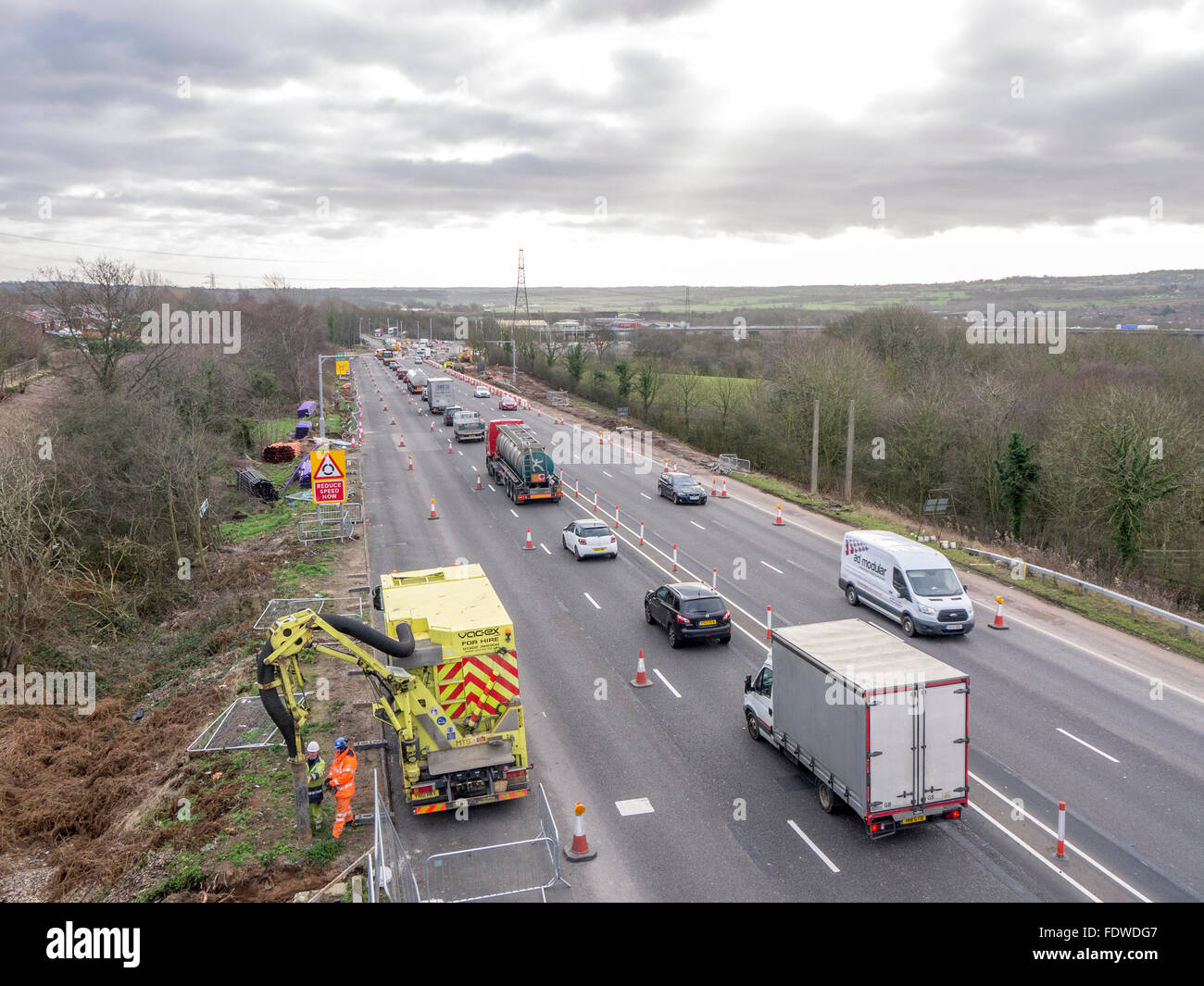 Workers on side of a coned off dual carriageway doing some vacuum ...