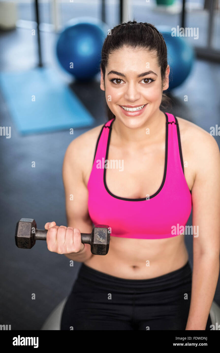 Smiling fit woman lifting dumbbell Stock Photo - Alamy