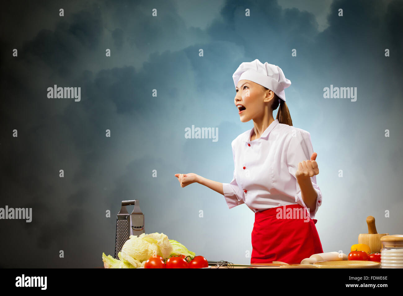 Asian female cook in anger against color background with shine effects ...