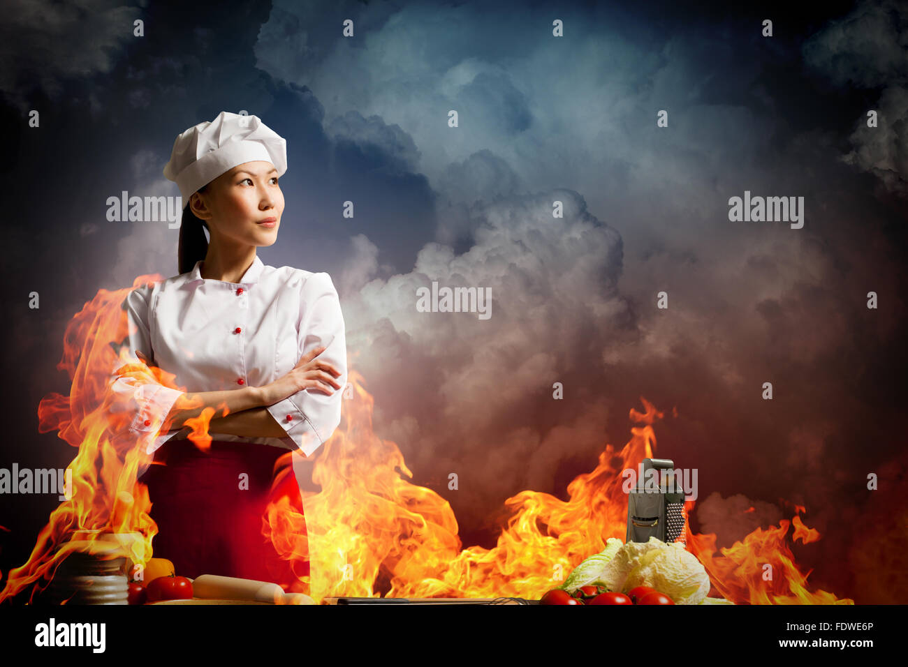 Asian female cook in anger against color background with shine effects ...