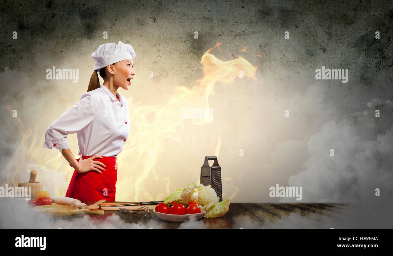 Asian female cook in anger against color background with shine effects ...