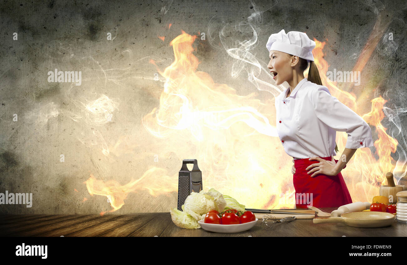 Asian female cook in anger against color background with shine effects ...
