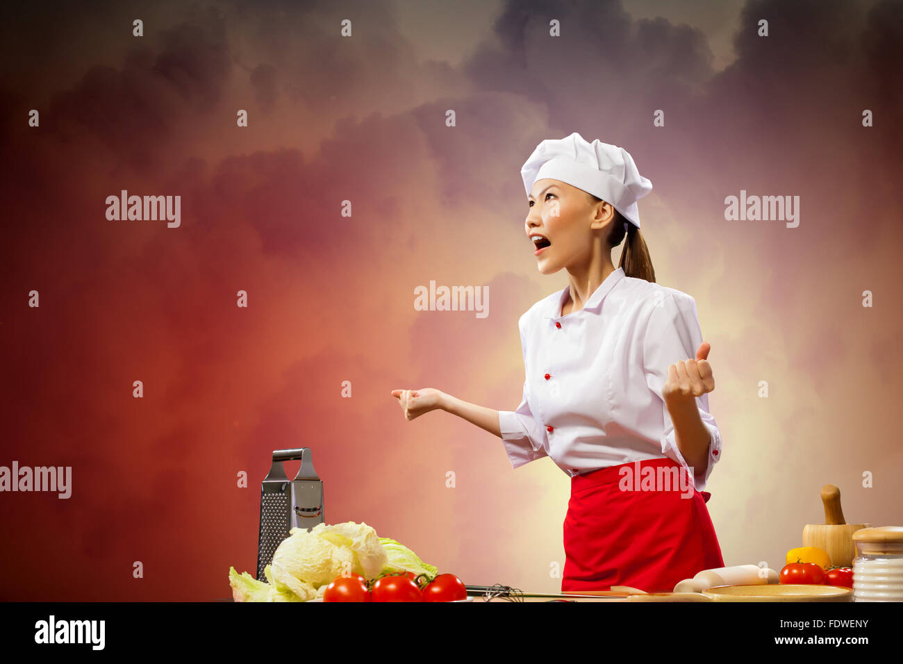 Asian female cook in anger against color background with shine effects ...