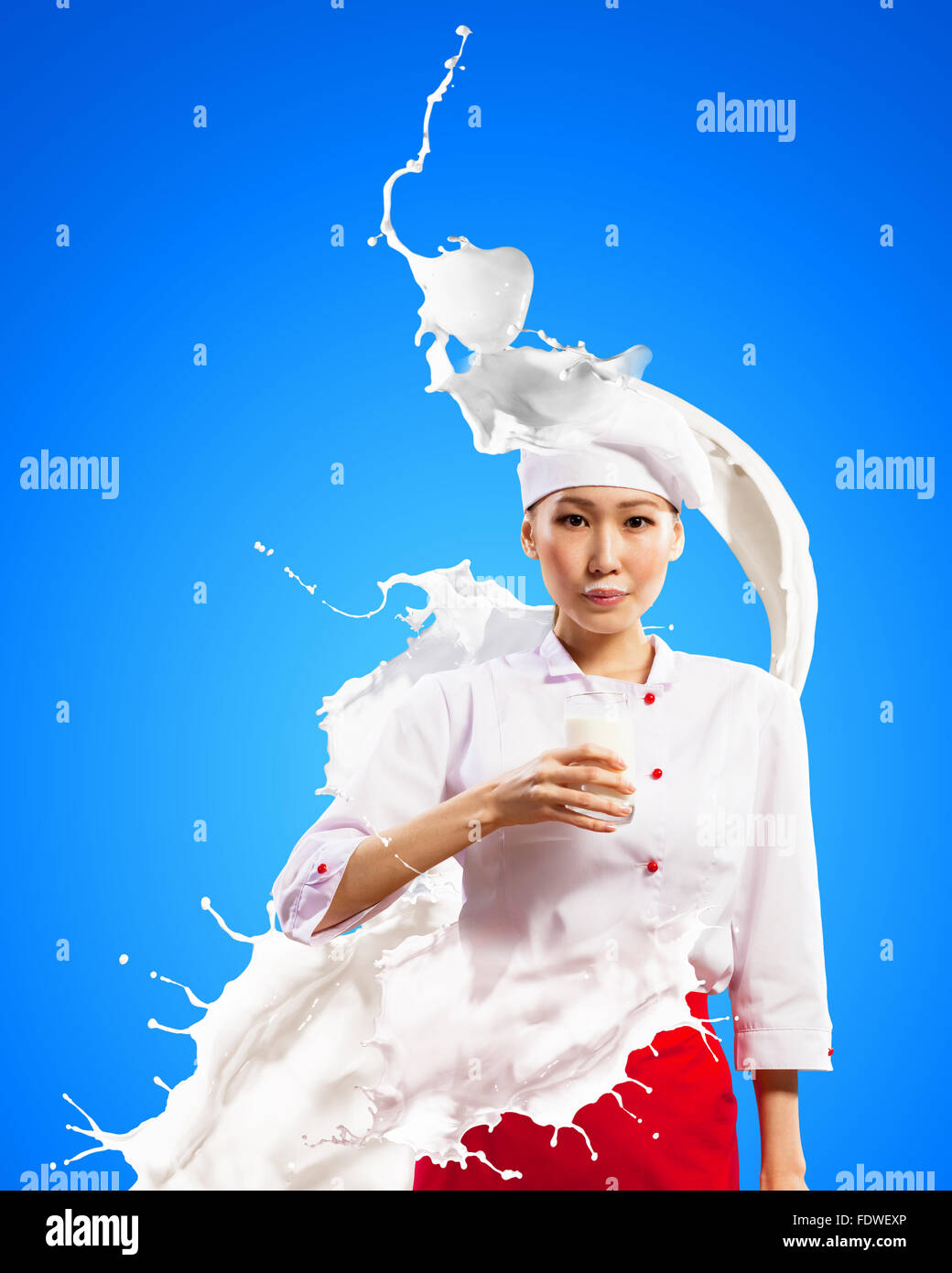 Asian female cook against milk splashes in red apron against color ...