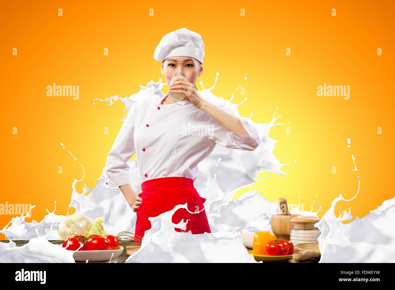 Asian female cook against milk splashes in red apron against color ...