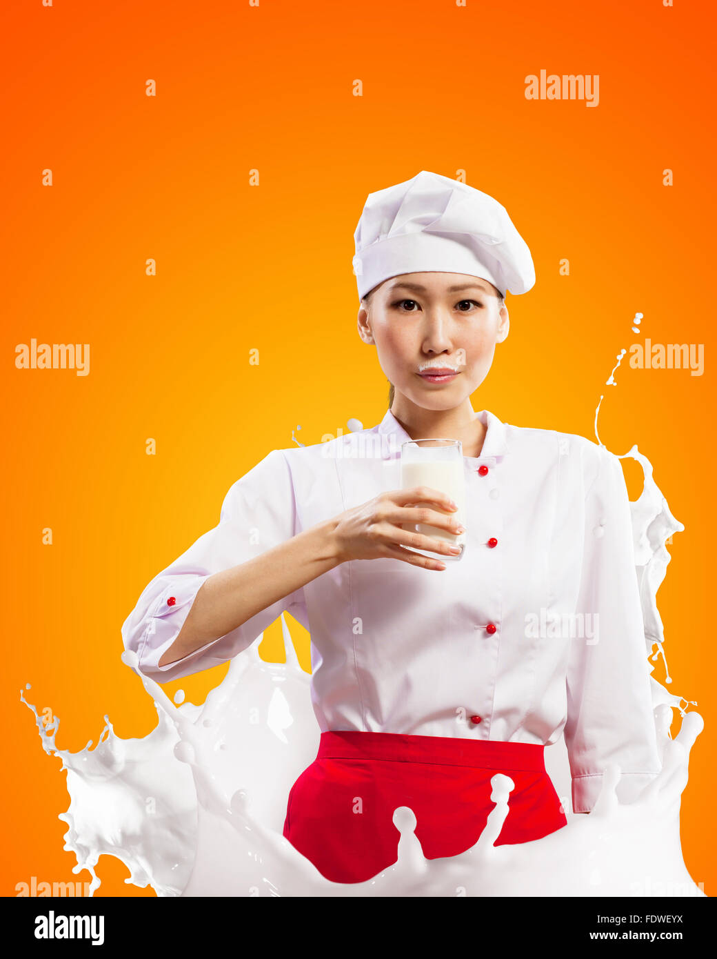 Asian female cook against milk splashes in red apron against color ...
