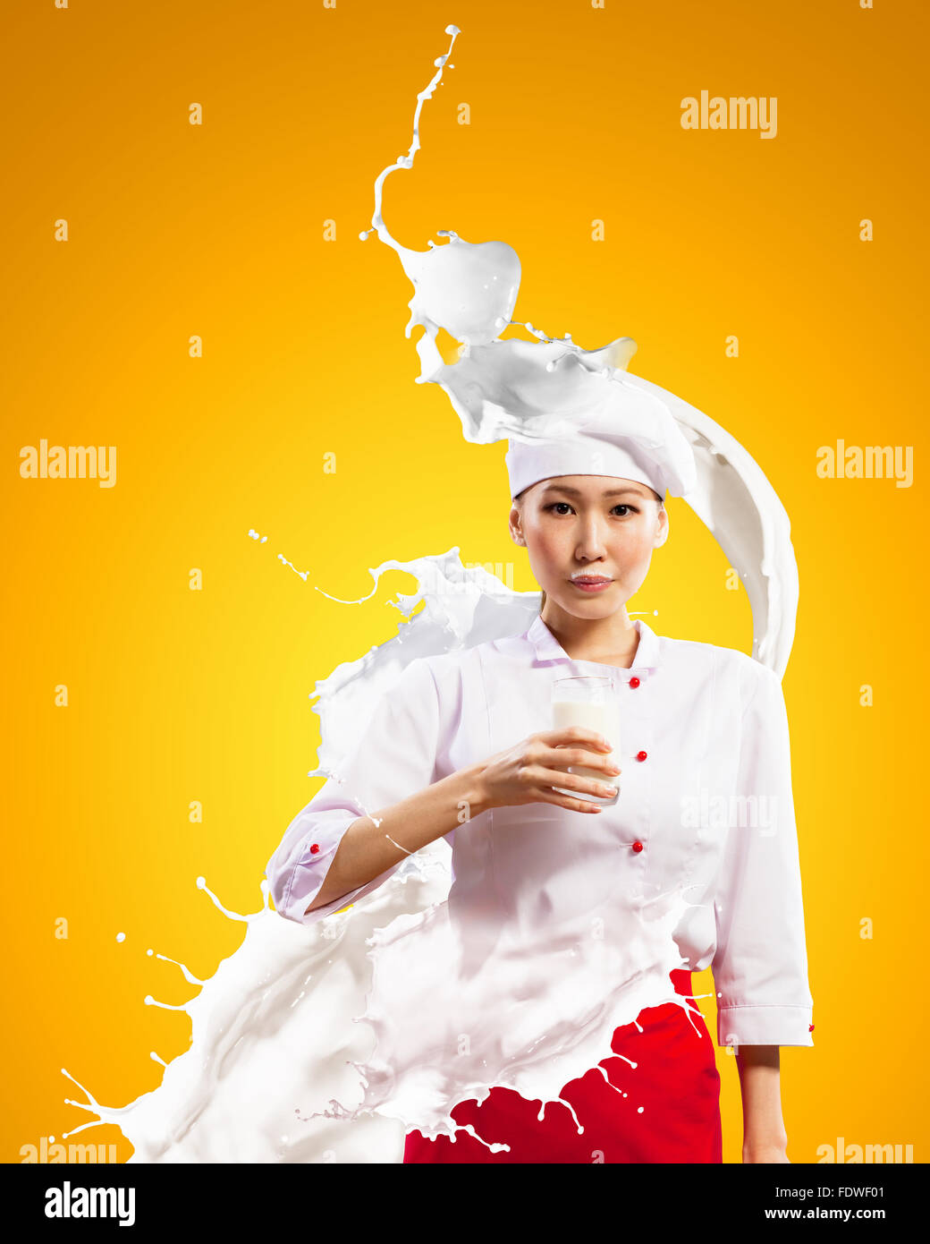 Asian female cook against milk splashes in red apron against color ...