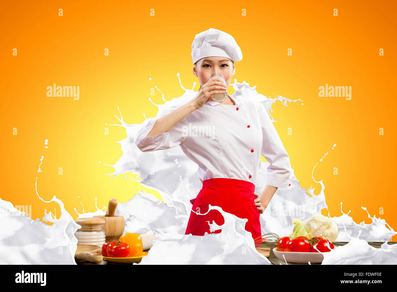 Asian female cook against milk splashes in red apron against color ...