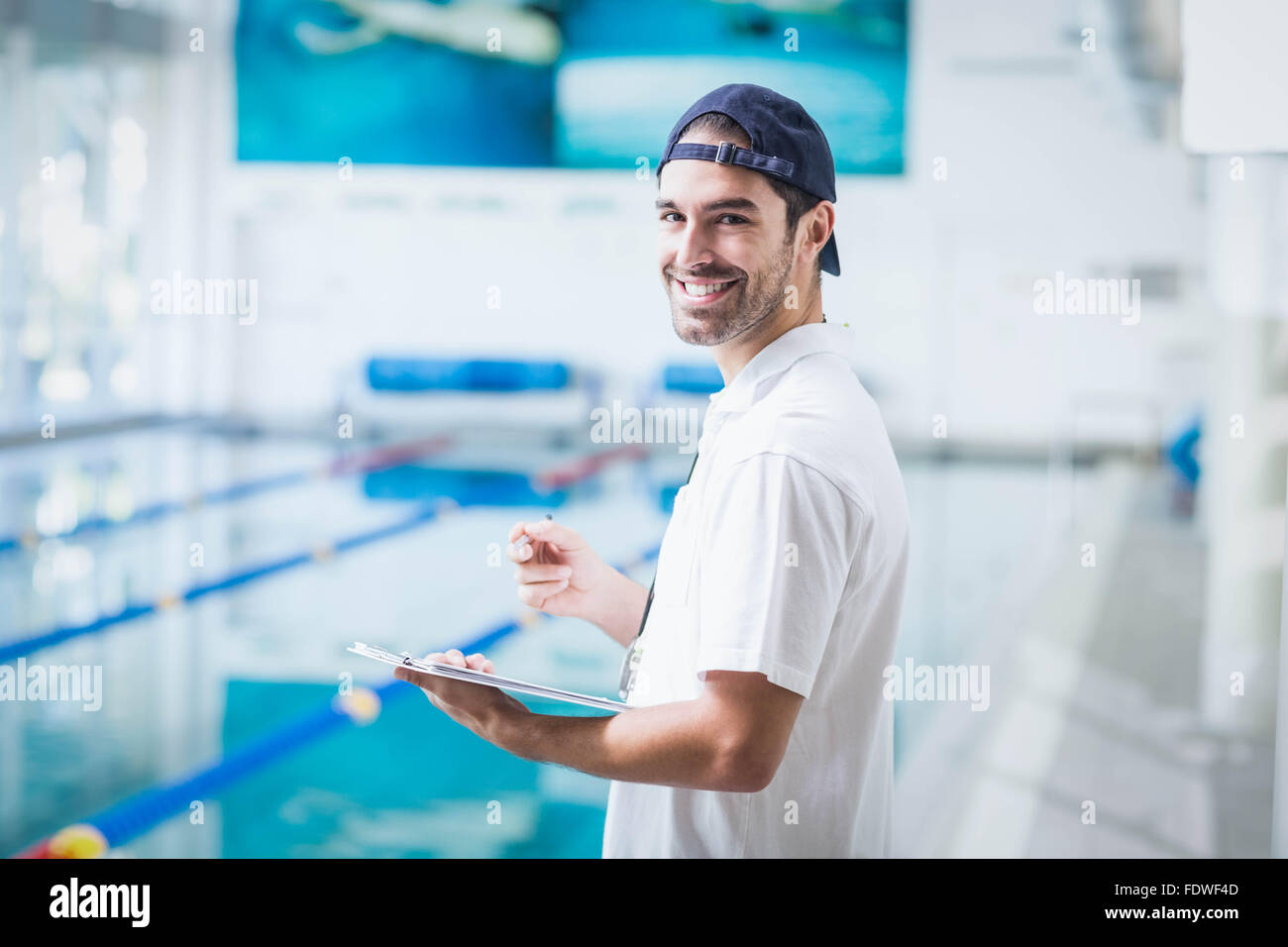 Smiling trainer holding clipboard Stock Photo - Alamy