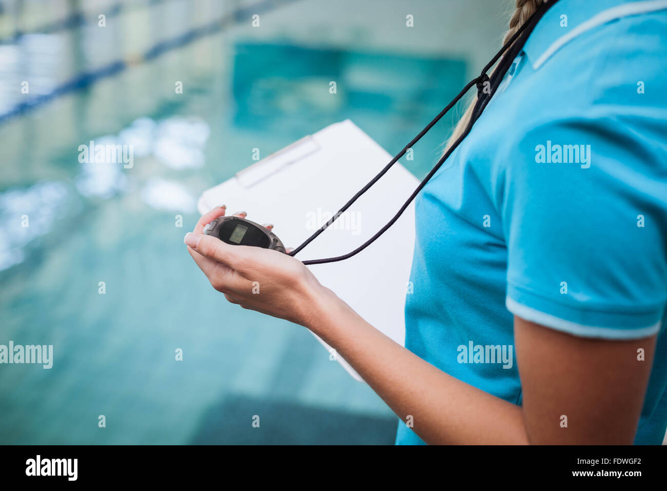 Pretty trainer looking at stopwatch Stock Photo - Alamy