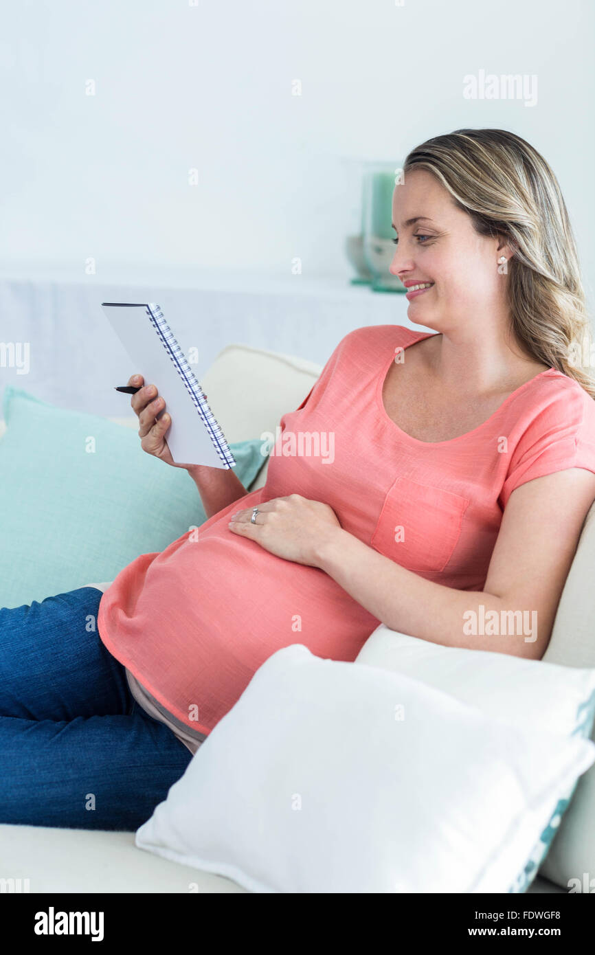 Pregnant woman writing on notepad Stock Photo - Alamy