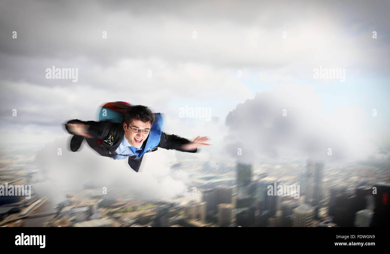 Conceptual image of young businessman flying with parachute on back ...