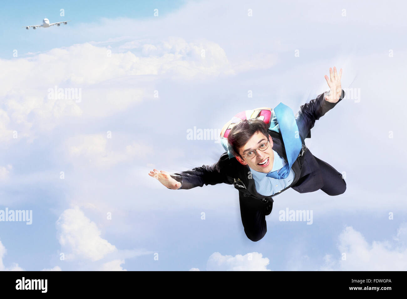 Conceptual image of young businessman flying with parachute on back ...