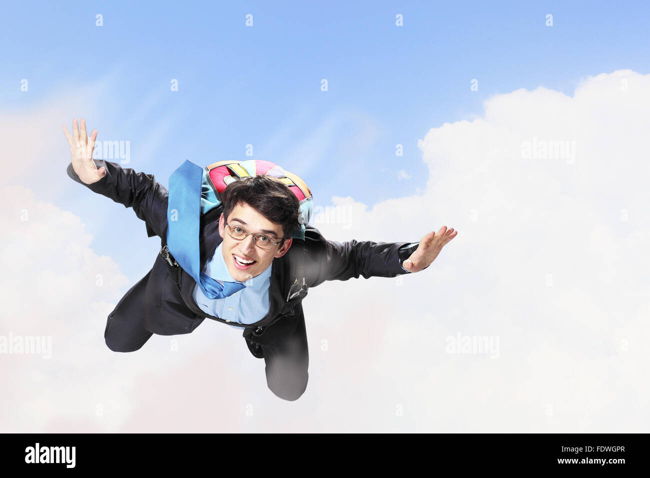 Conceptual image of young businessman flying with parachute on back ...