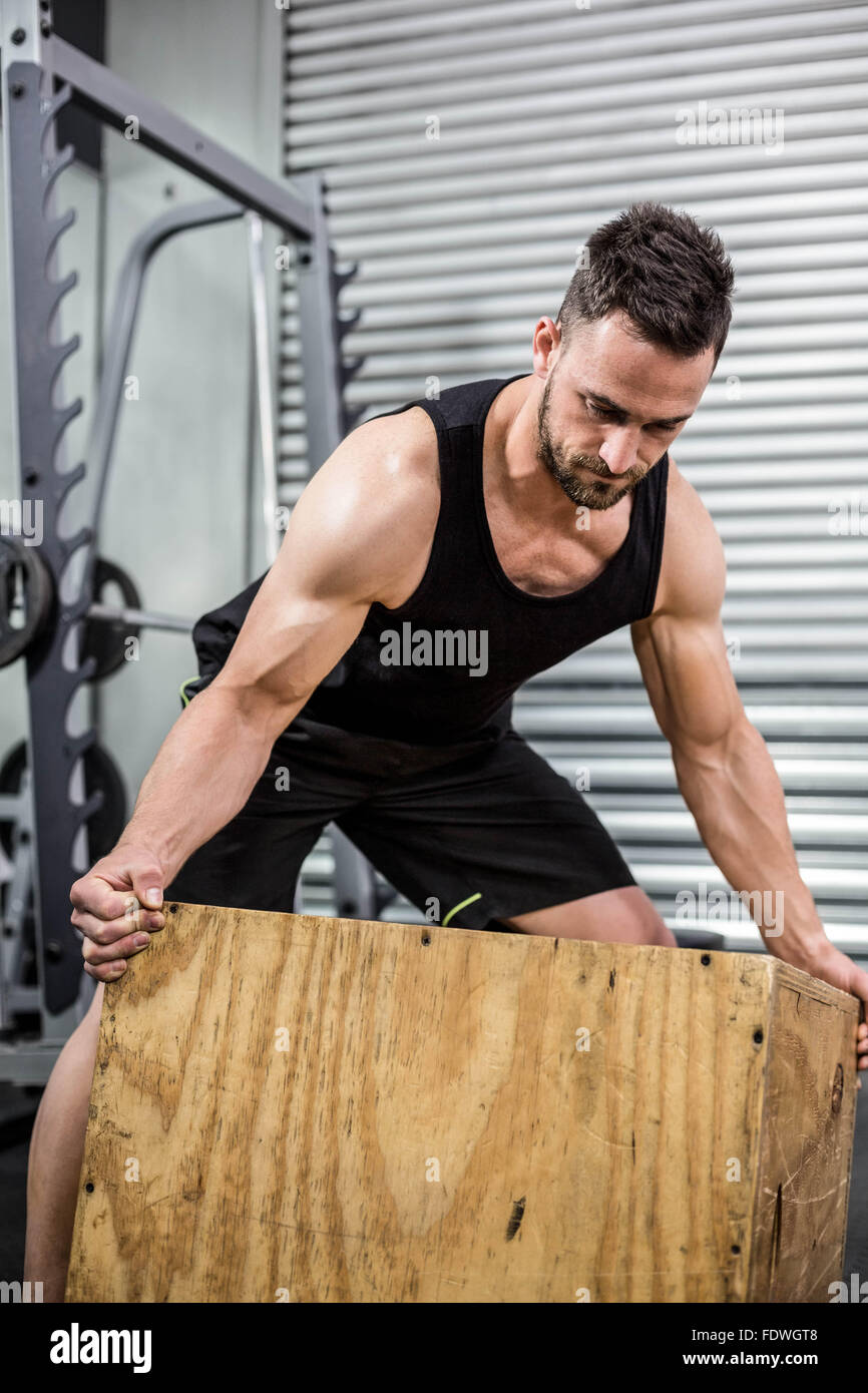 Fit man moving wooden box Stock Photo - Alamy